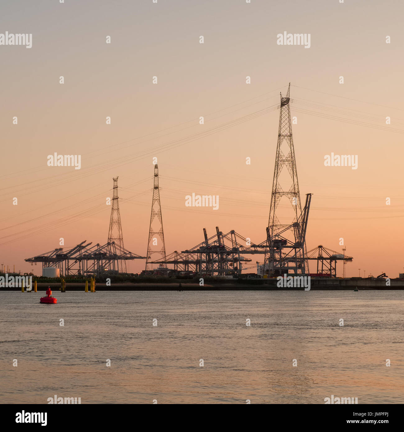 Image shows an electricity pylon against a sunset sky in front of a ...