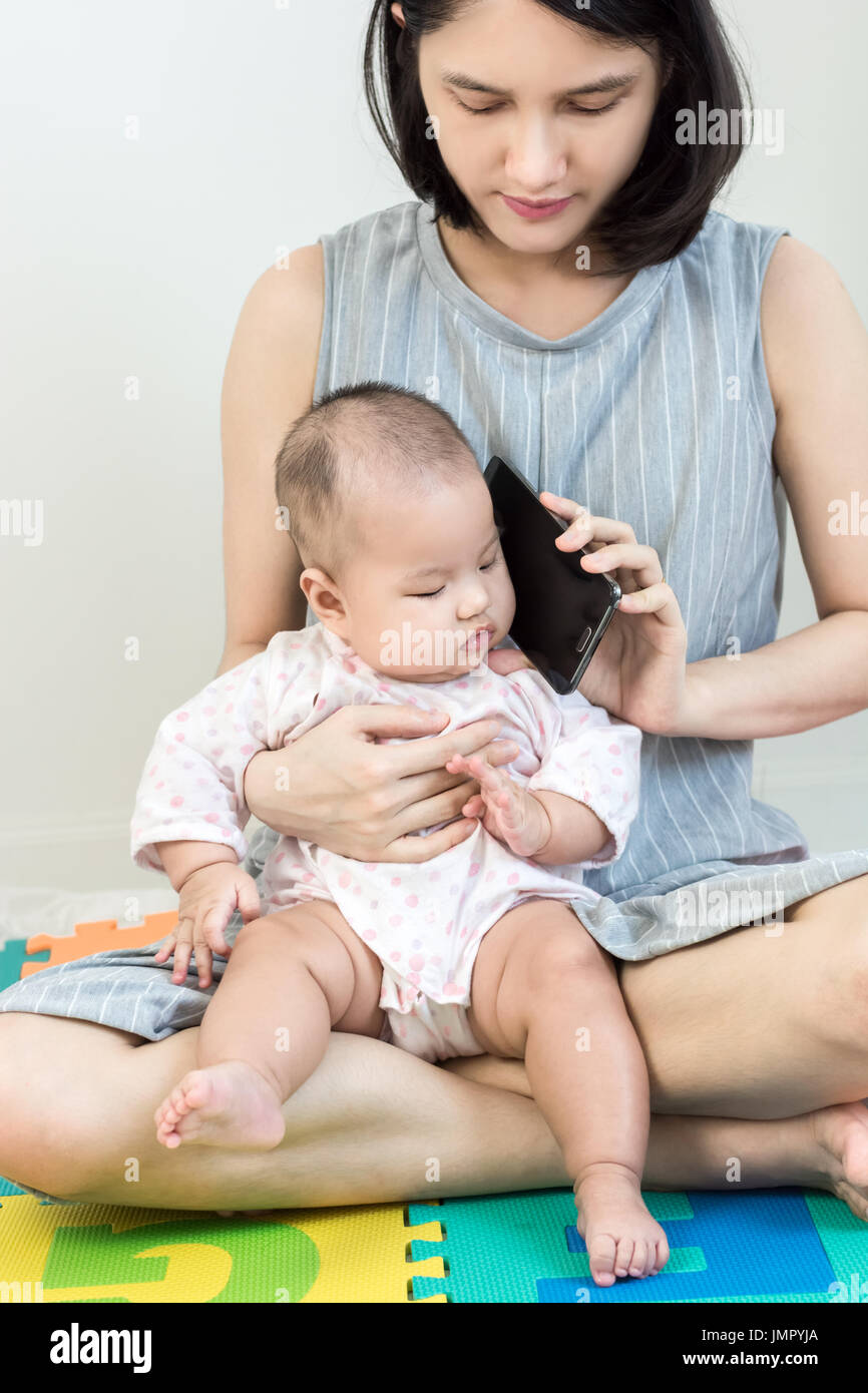 Portrait of a little adorable infant baby girl sitting on mother lap on ...