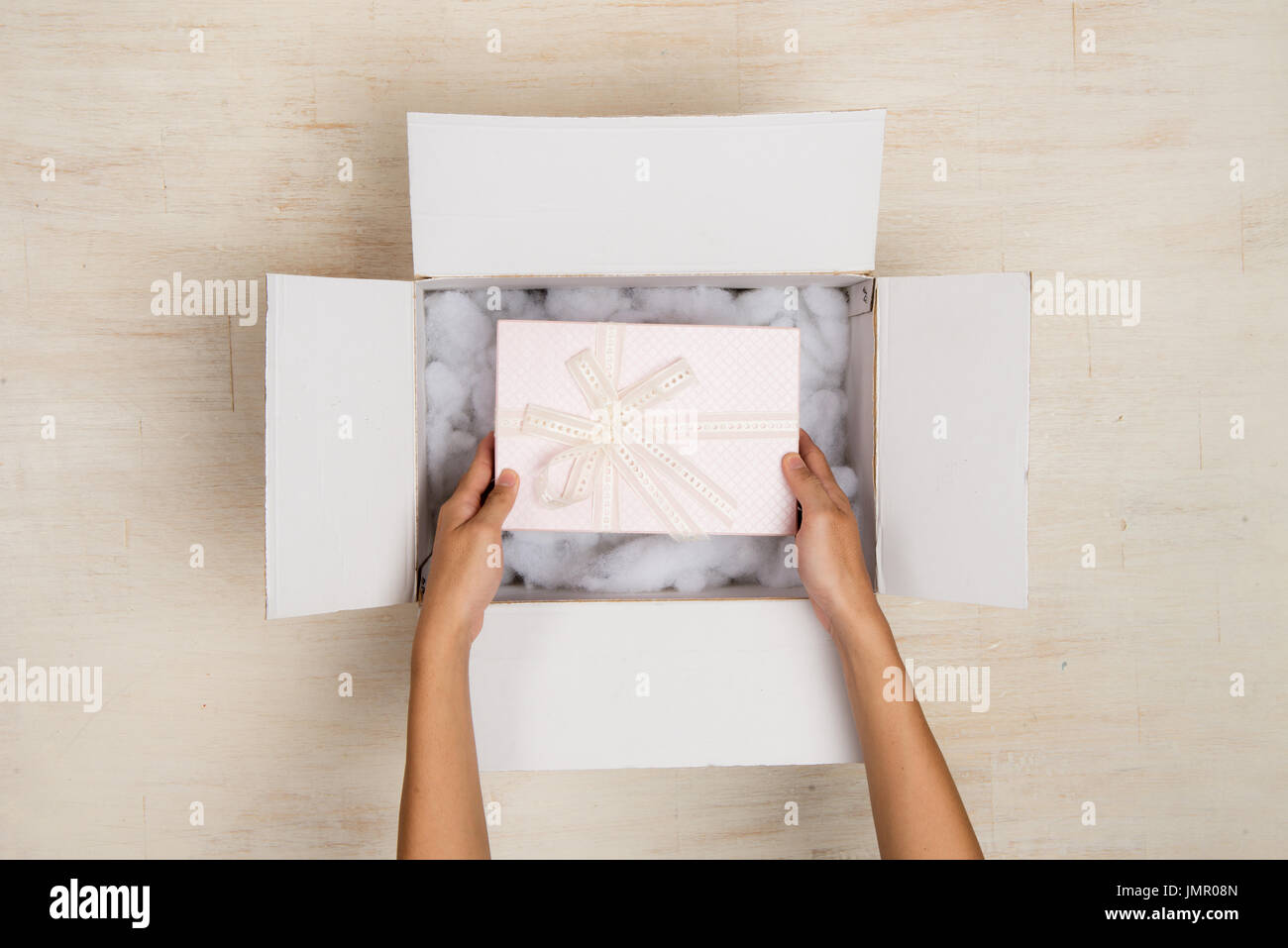 Opening a carton box. Hands holding gift box in cardboard box Stock ...