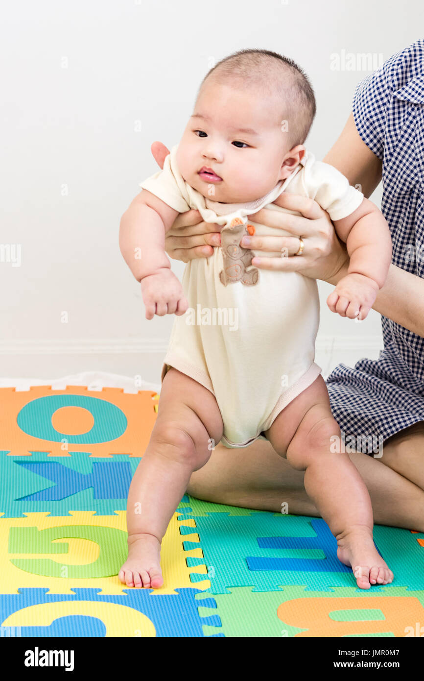 Portrait of a little adorable newborn infant baby girl standing up with ...