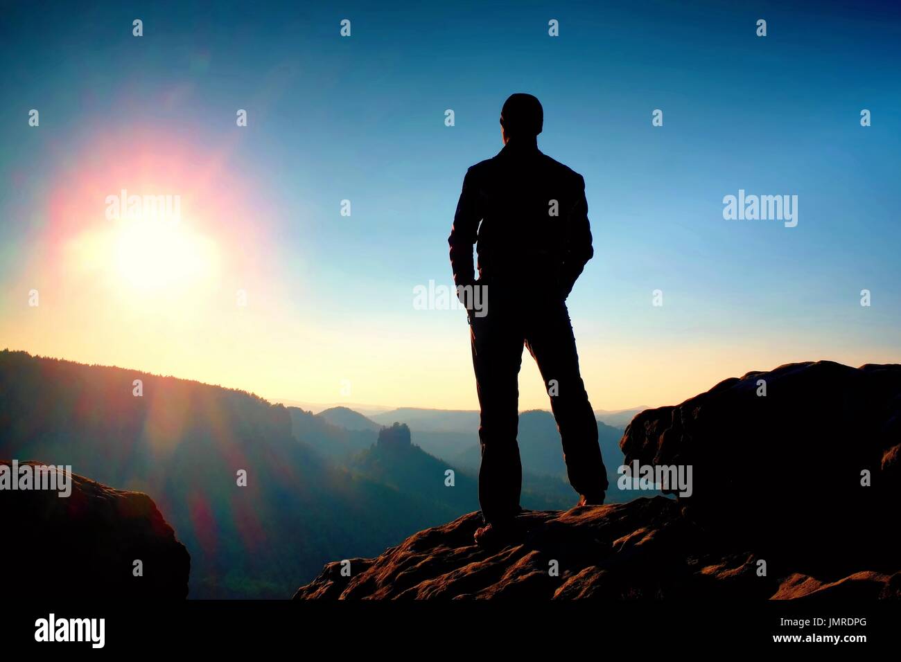 Slim tourist on the sharp peak of rock in rock empires park is watching ...