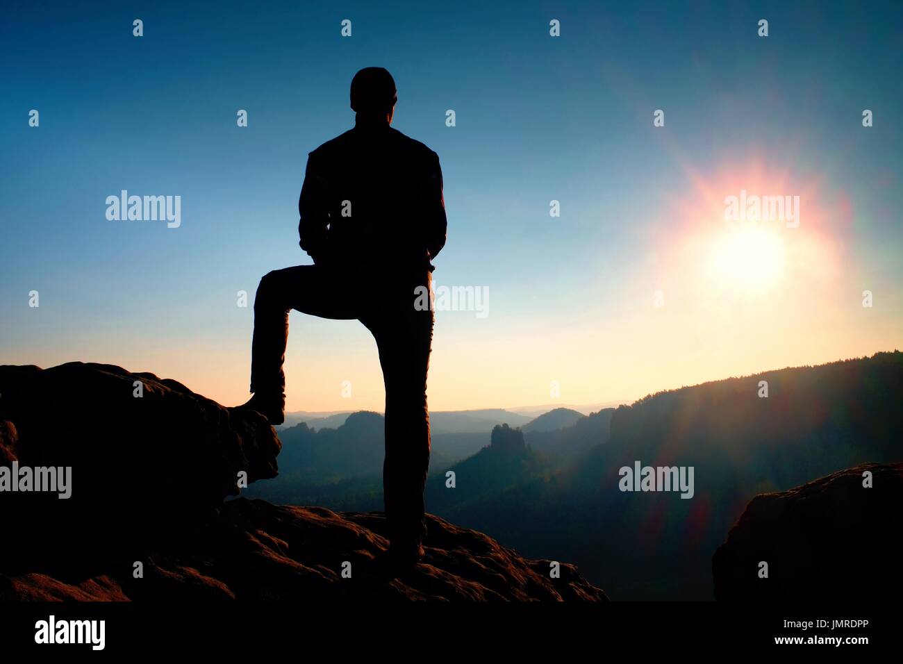 Tall male hiker in the mountain landscape at sunset. Beautiful colorful ...