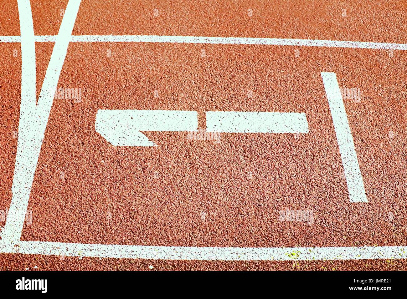 Number one. White track number on red rubber racetrack, texture of ...