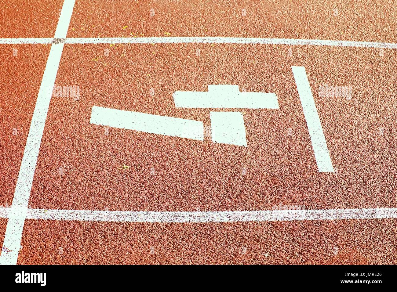 Number four. White track number on red rubber racetrack, texture of ...