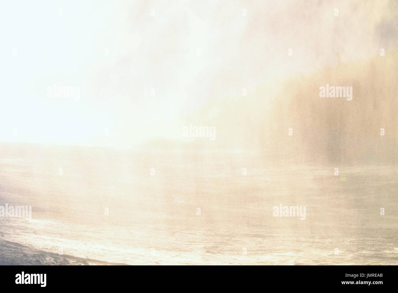 Snowmaking on slope. Skier near a snow cannon making fresch powder snow ...