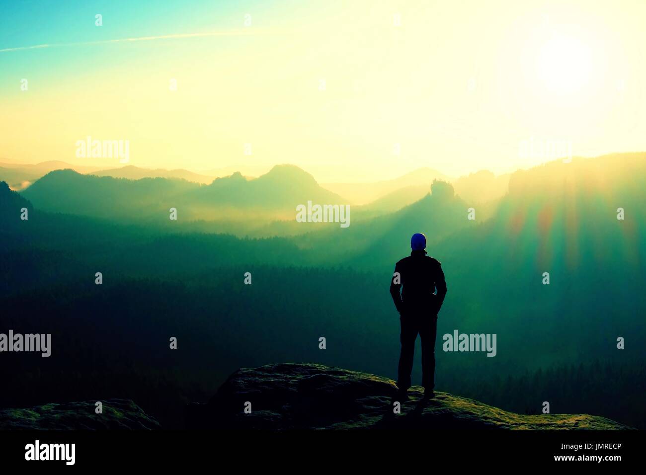 Slim tourist on the sharp peak of rock in rock empires park is watching ...