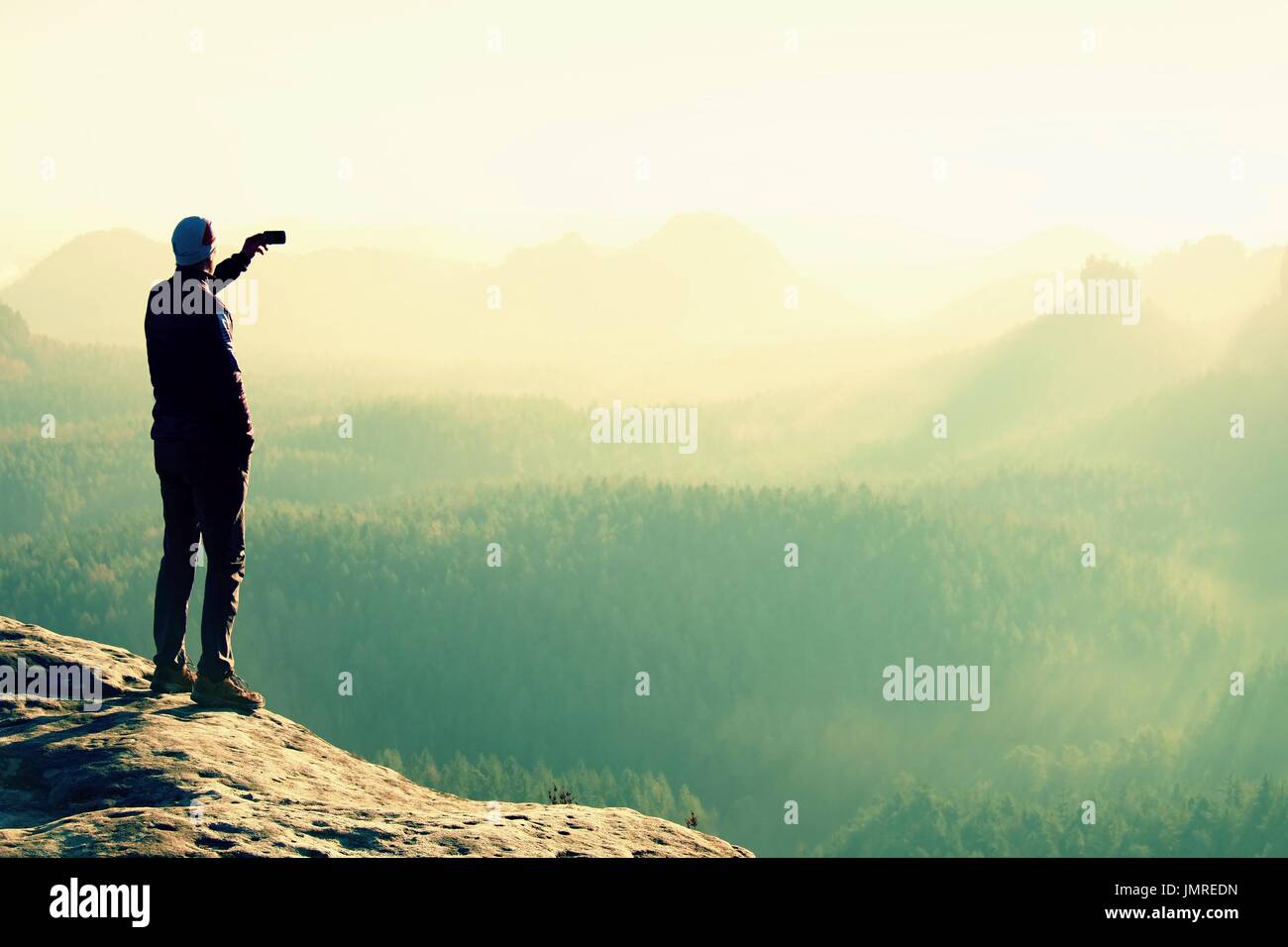 Slim tourist on the sharp peak of rock in rock empires park is watching ...