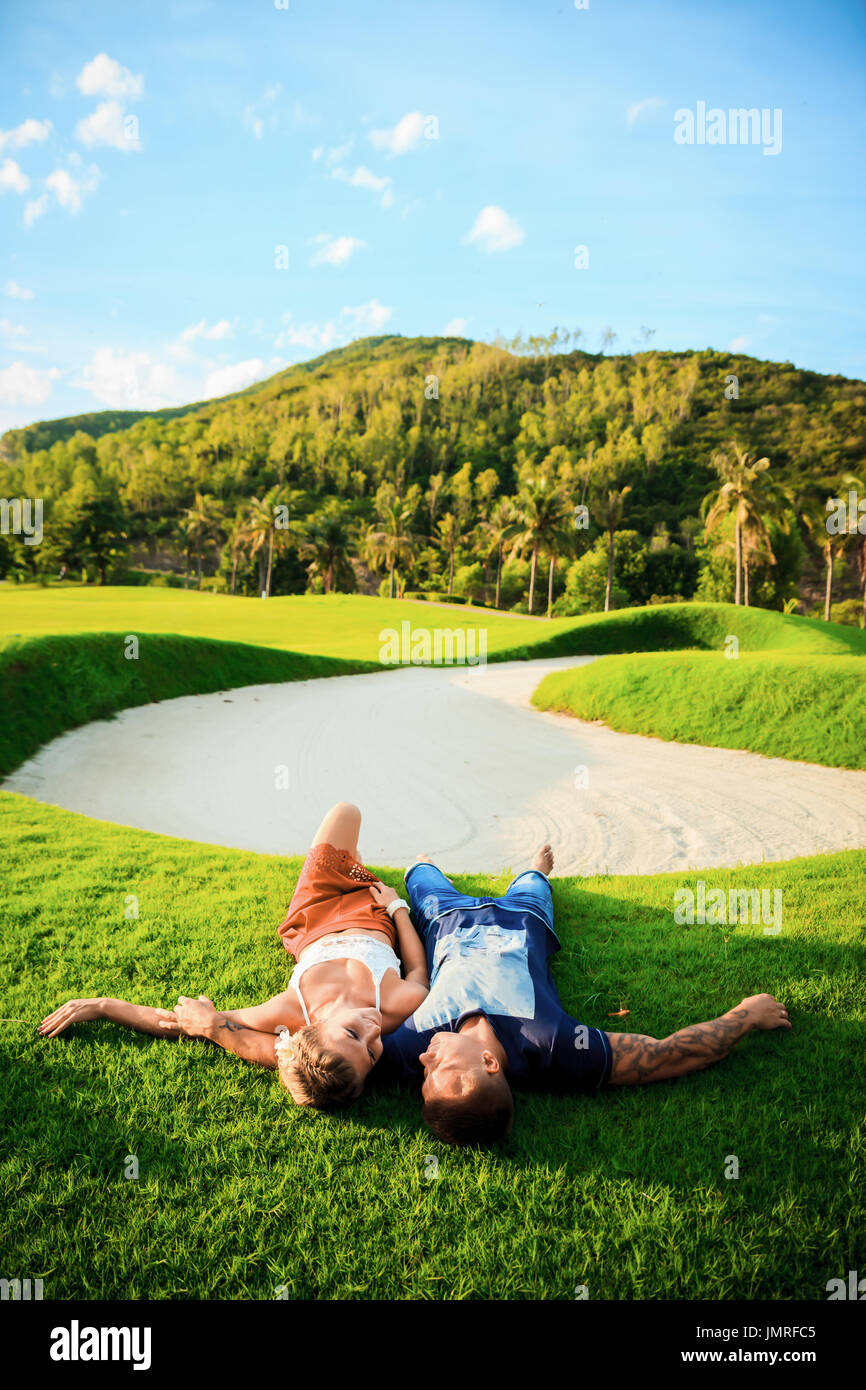 Happy relaxed couple in love laying down on the grass overhead Stock ...