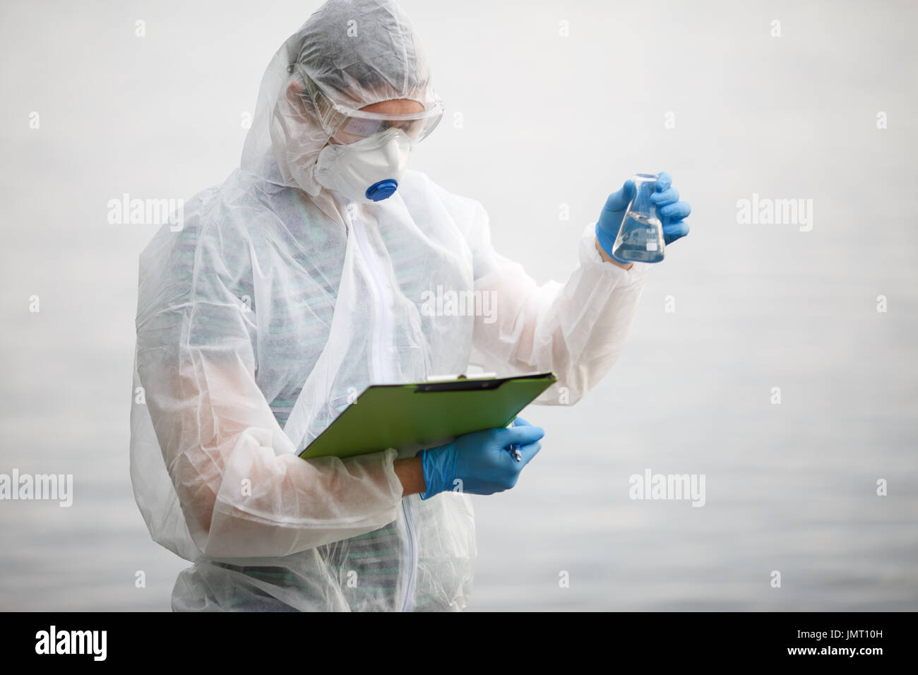 Ecologist with bulb and folder on river bank, blurred background Stock ...