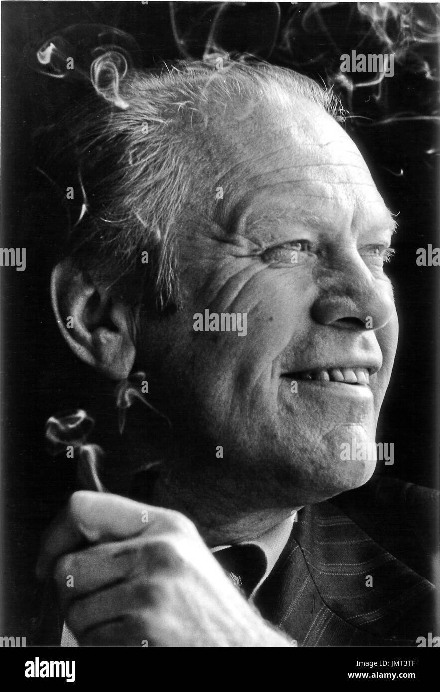 Smoke curls around United States President Gerald R. Ford as he enjoys ...