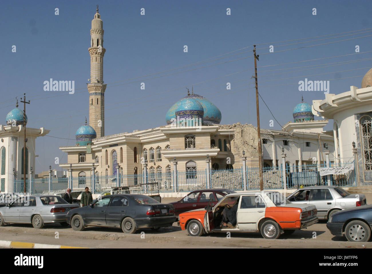 Lines of vehicles and people mass in front of a mosque in downtown ...