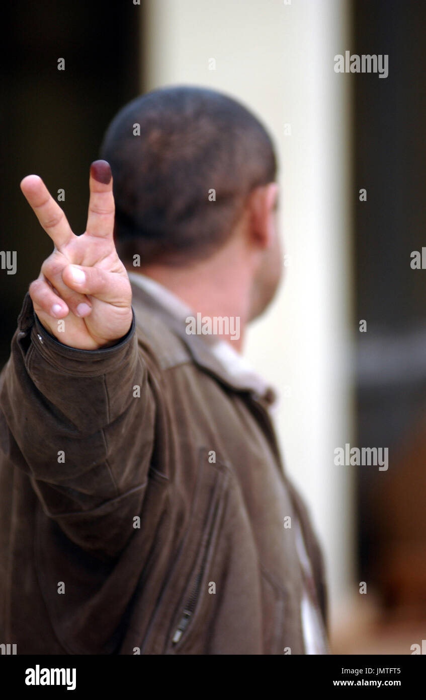 An Iraqi citizen, turning his head to protect his identity, proudly ...