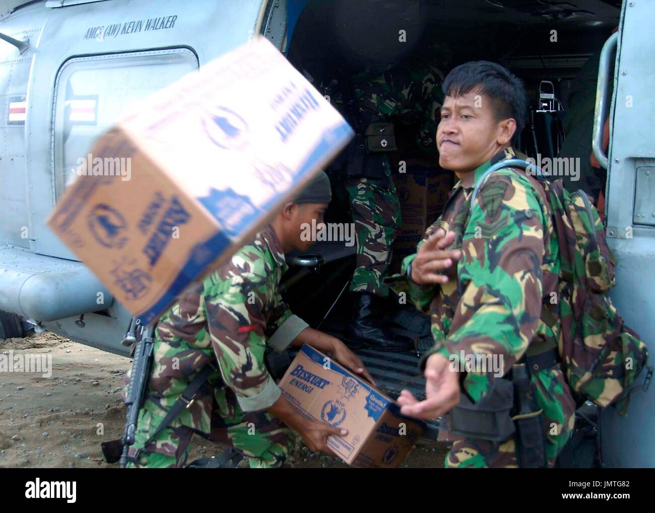 An Indonesian Army Commando tosses supplies from a SH-60F assigned to ...