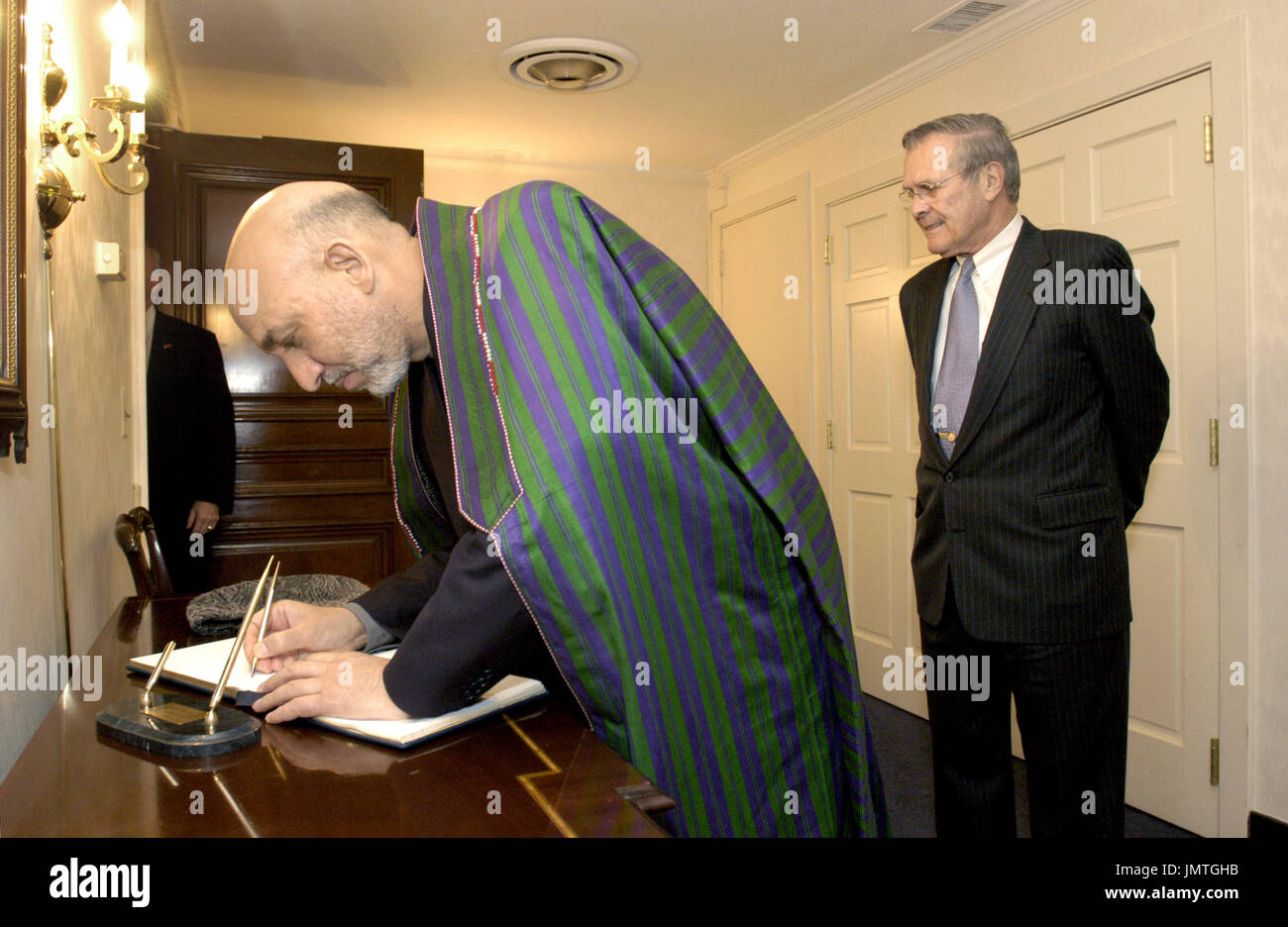 President Hamid Karzai of Afghanistan (left) signs the guest book at ...