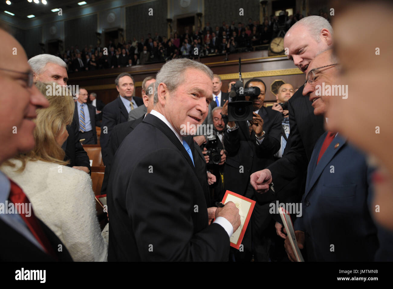 US President George W. Bush (C) signs autographs after delivering the ...