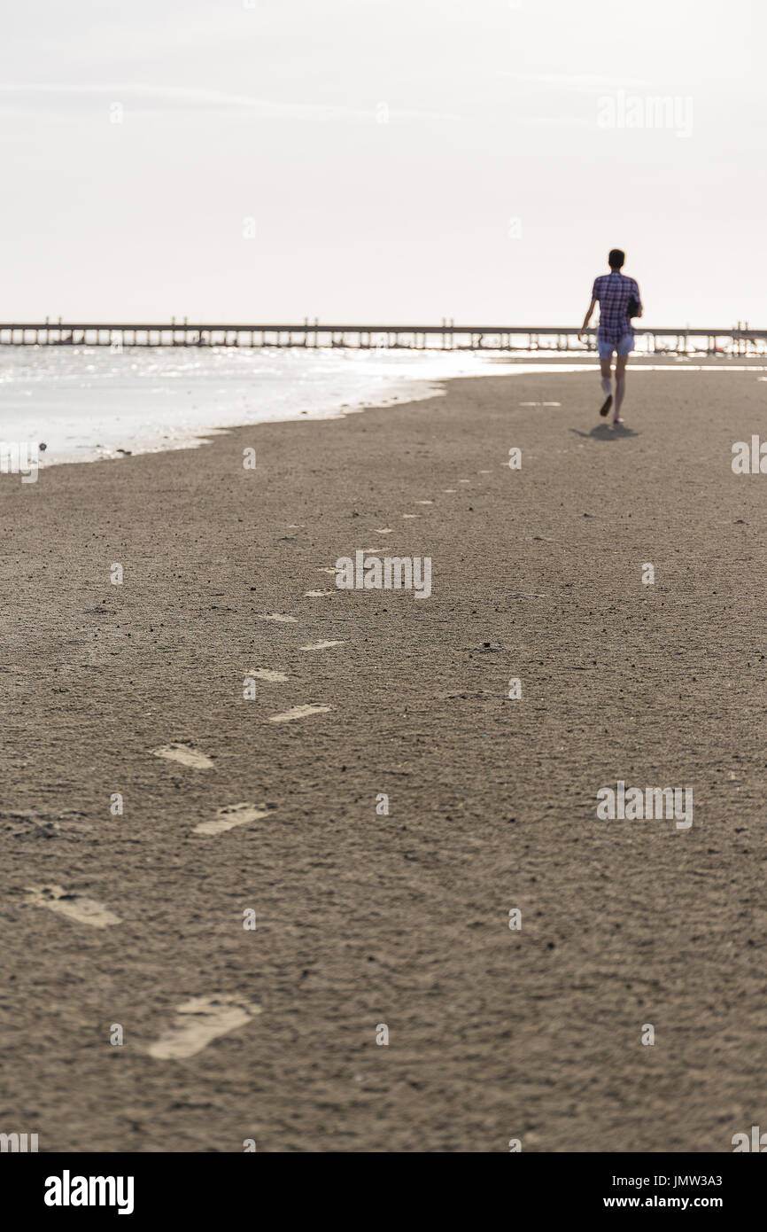 Footprint of running man on beach Stock Photo - Alamy