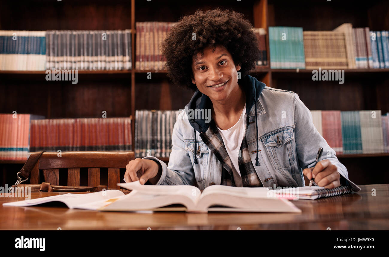 Young confident student learning from books in library. university ...