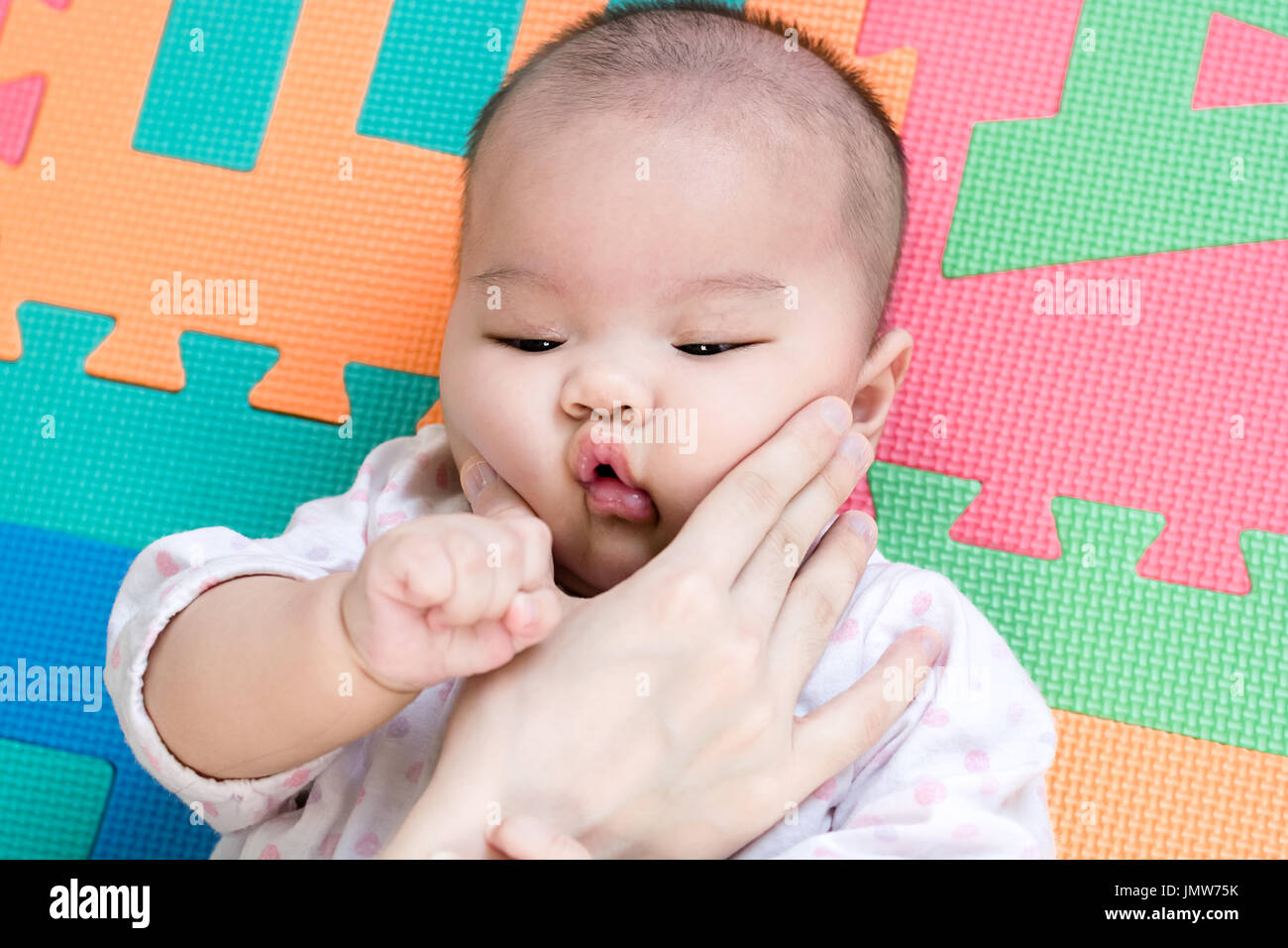 Parent pinch the cheeks a little adorable newborn infant baby girl that ...
