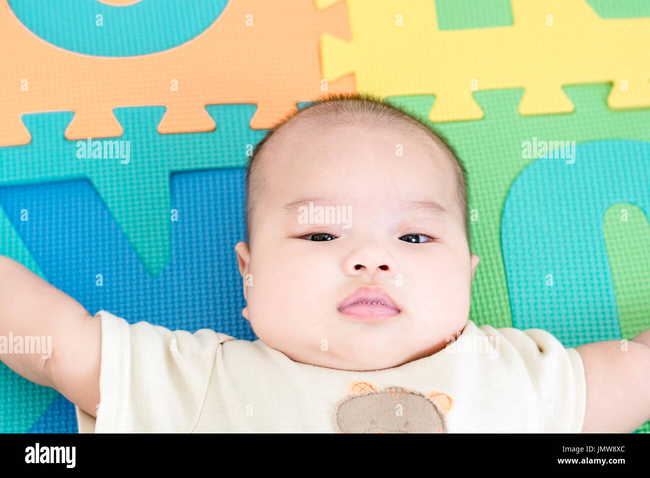 Portrait of a little adorable infant baby girl lying on back on ...