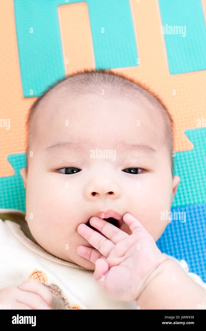 Portrait of a little adorable infant baby girl lying on back on ...