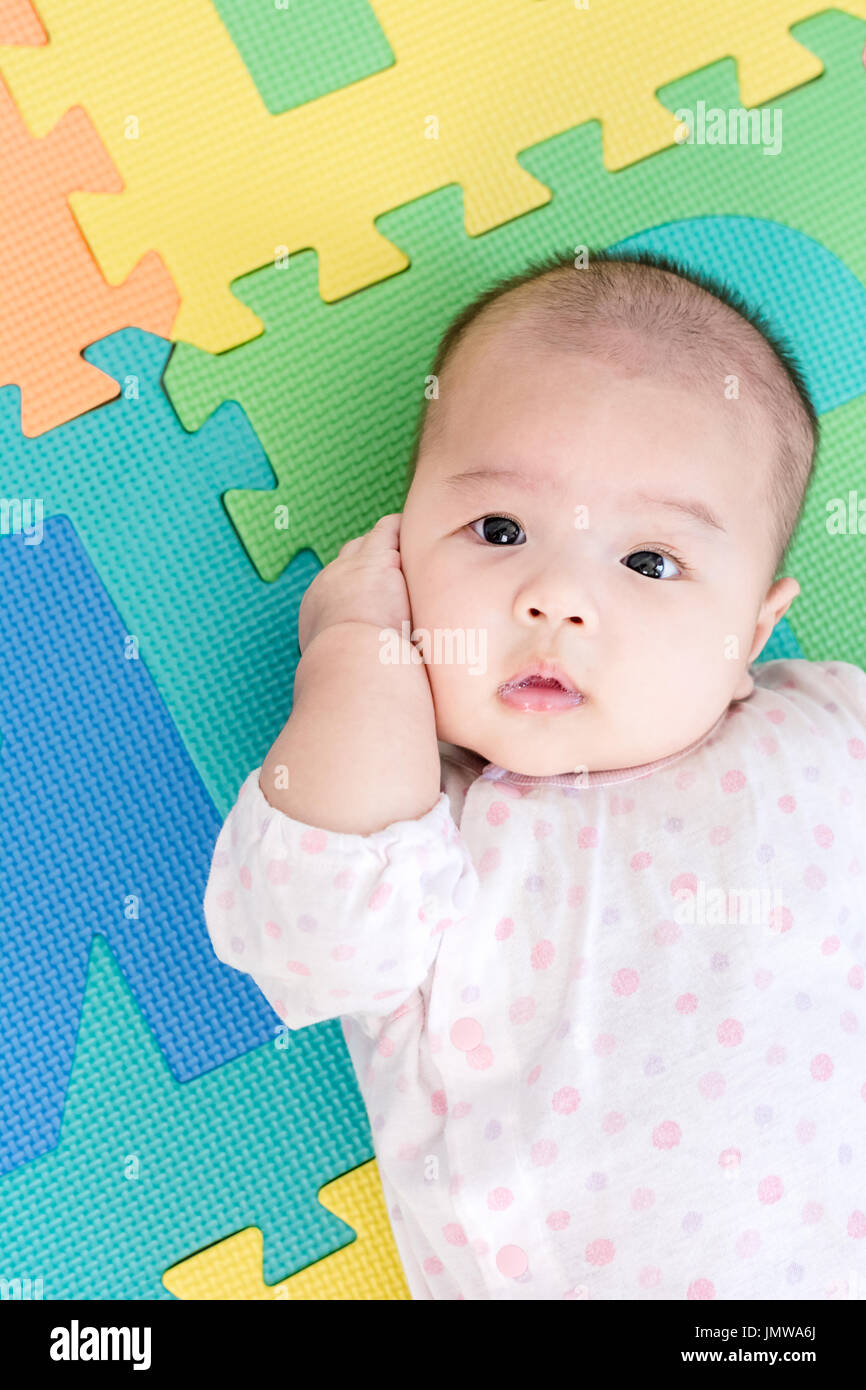 Portrait of a little adorable infant baby girl lying on back on ...