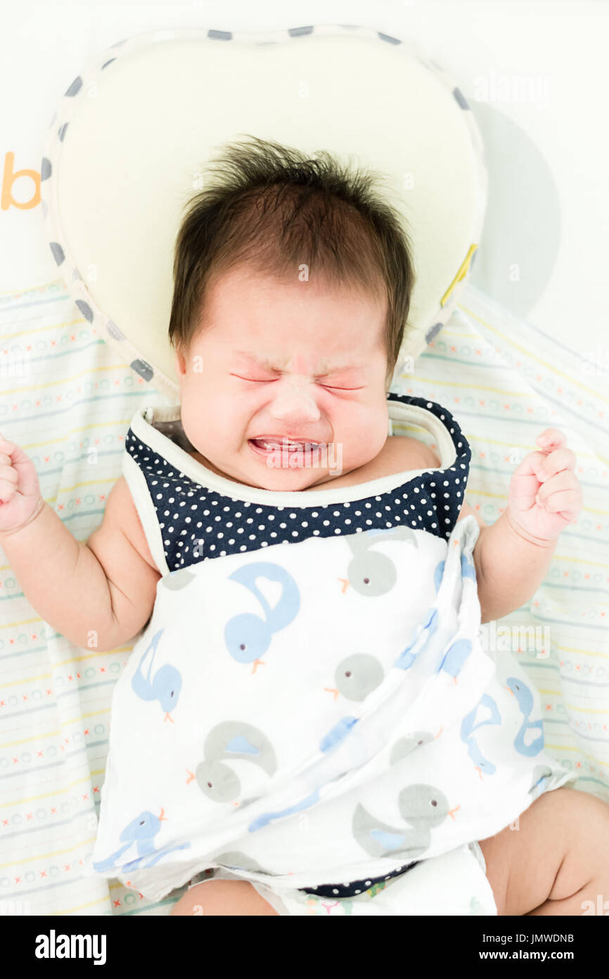 Portrait of a little adorable infant baby girl lying on back on the bed ...