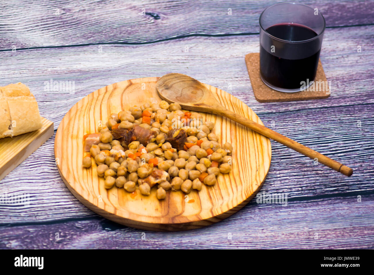 Madrid stew on a plate on a wooden table With bread and a glass of red ...