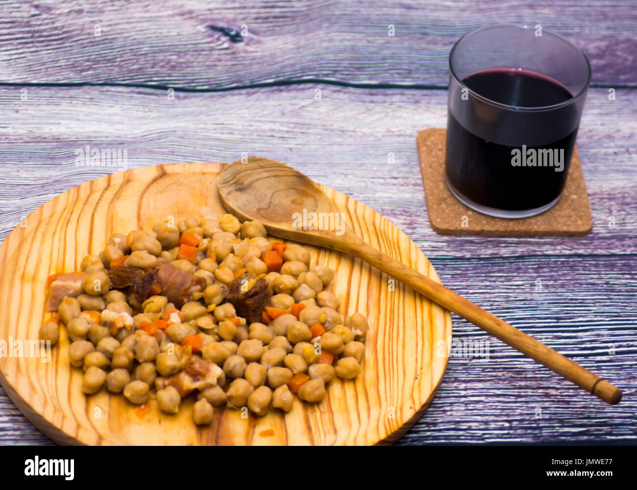 Madrid stew on a plate on a wooden table With a glass of red wine ...
