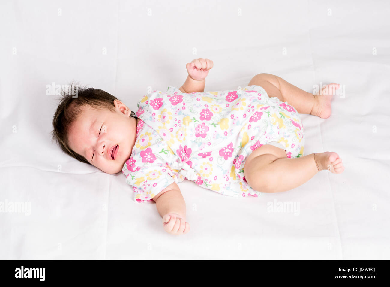 Portrait of a little adorable infant baby girl lying on back on the bed ...