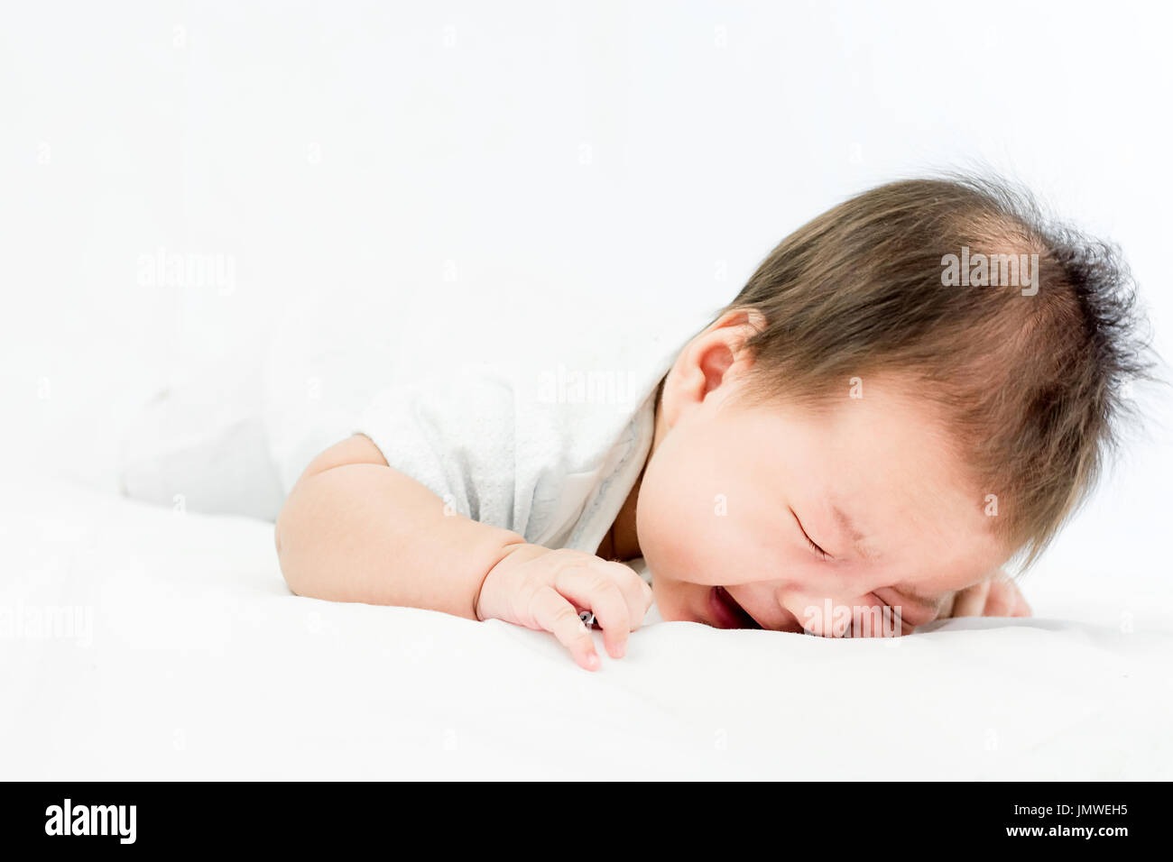 Portrait of a little adorable infant baby girl lying on back on the bed ...