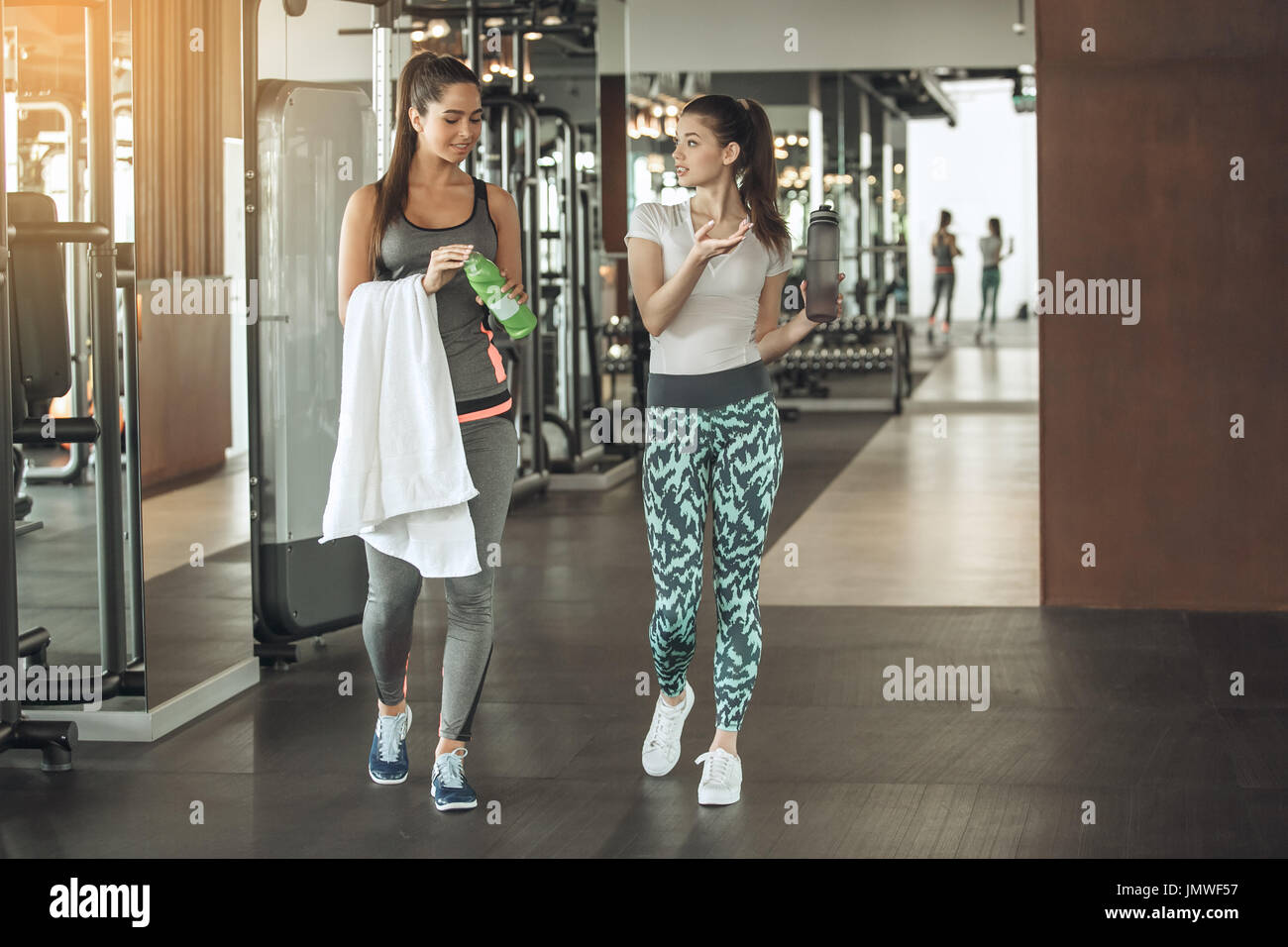 Young female friends exercise in the gym with water bottles Stock Photo ...