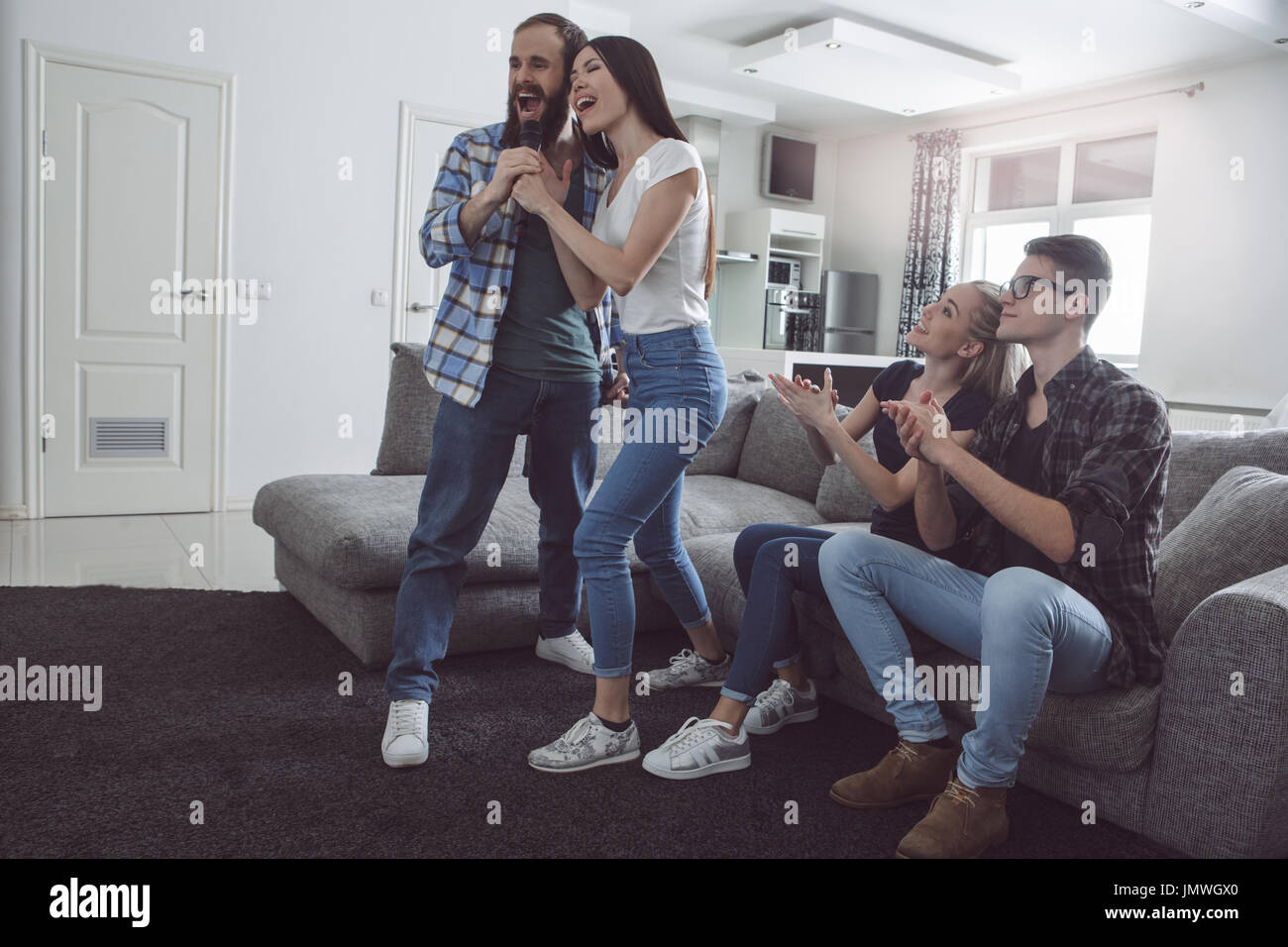 Happy friends singing karaoke party hi-res stock photography and images ...