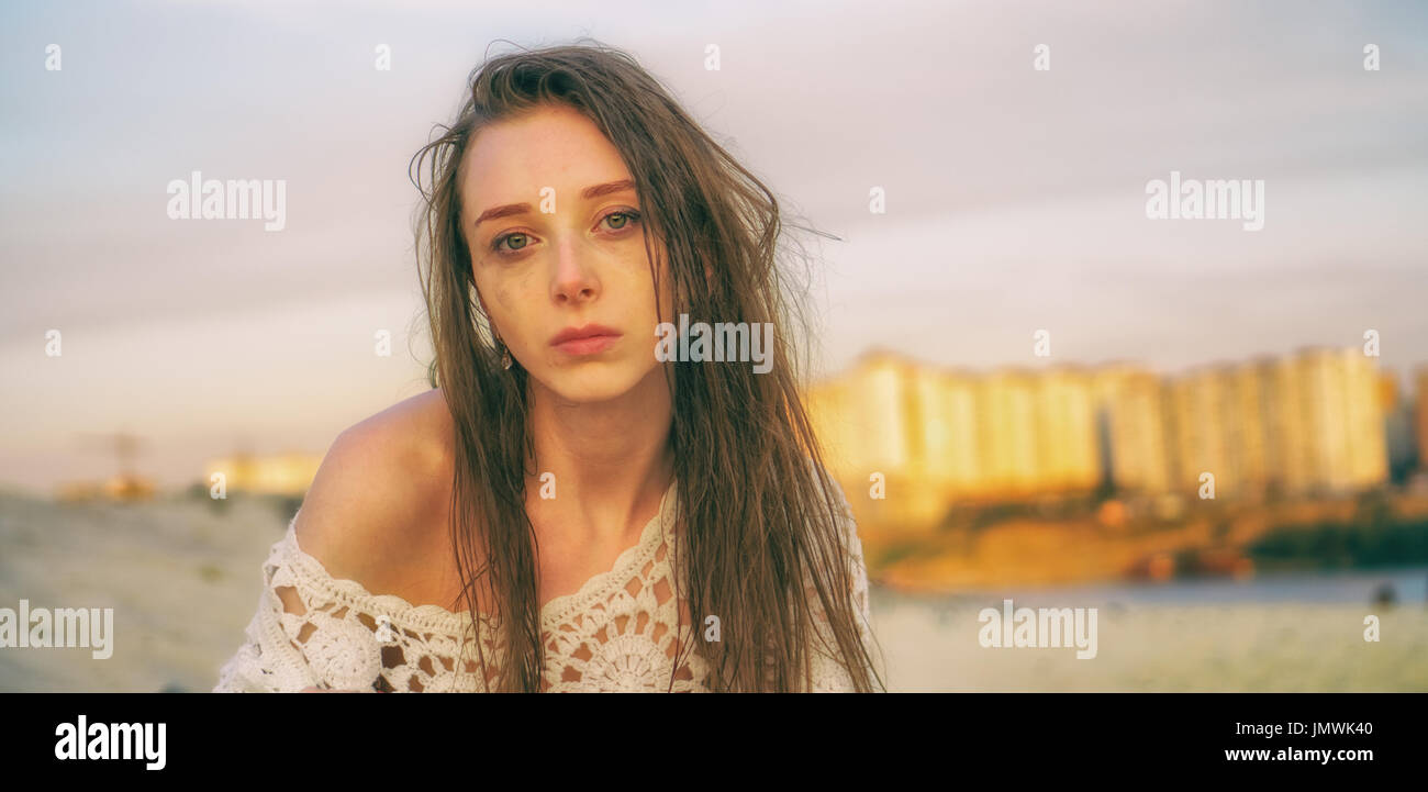Beautiful girl crying at sunset against city background Stock Photo - Alamy