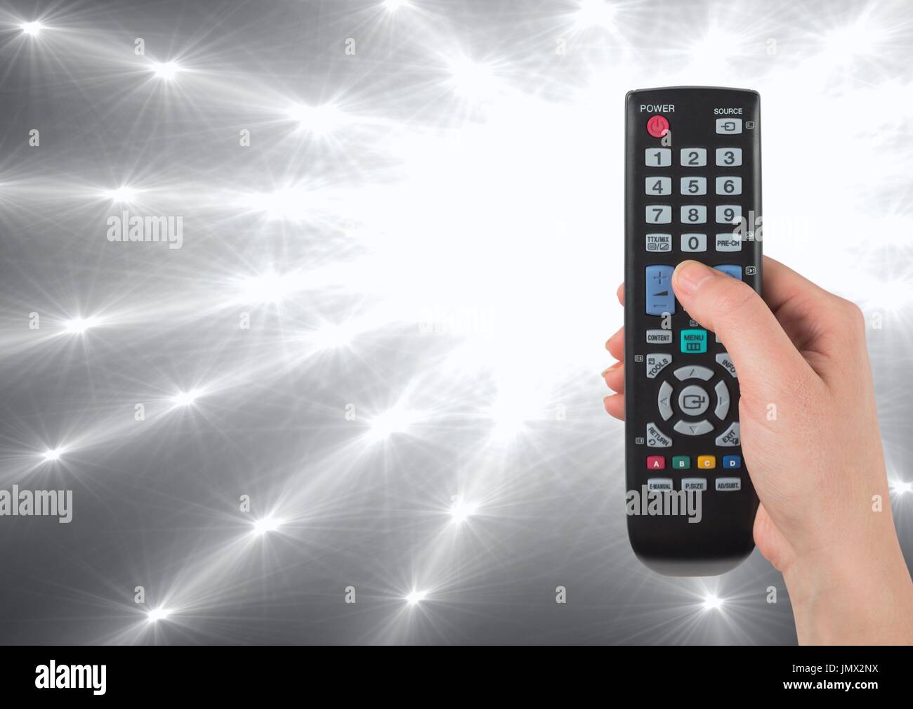 Digital composite of TV remote control with bright light shining out of ...