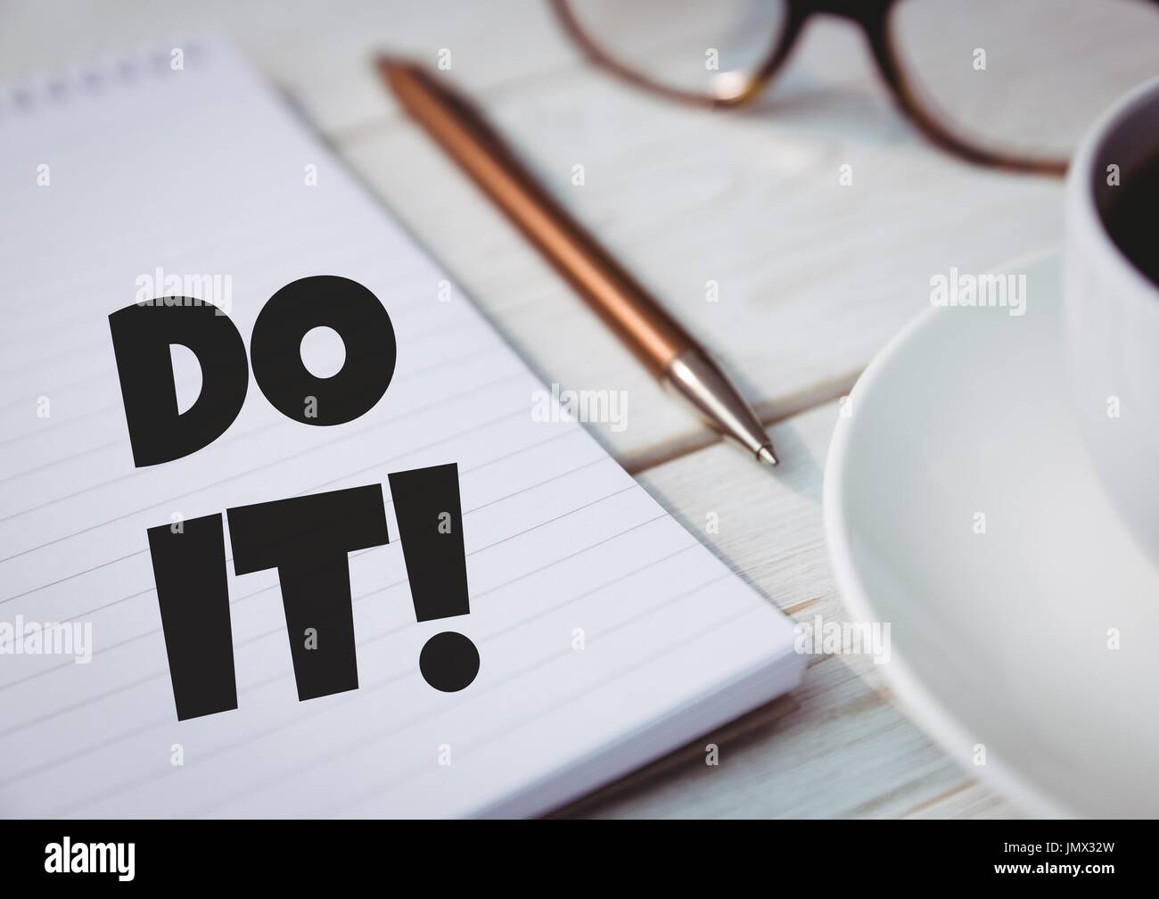 Digital composite of Do It! text written on page with glasses and pen ...