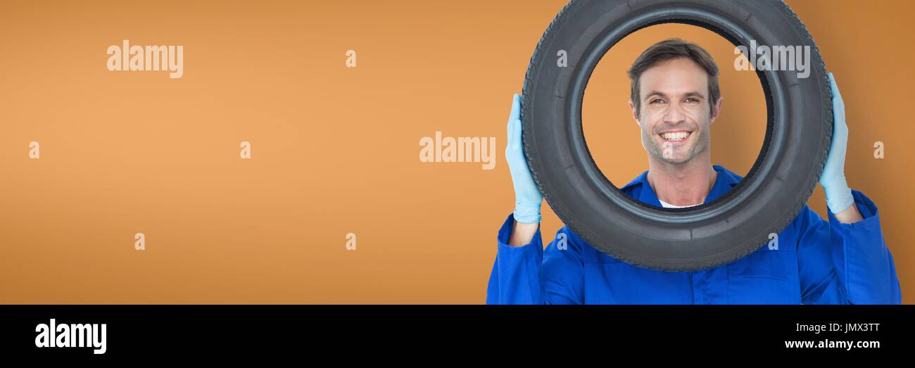 Digital composite of Happy mechanic man holding a wheel Stock Photo - Alamy