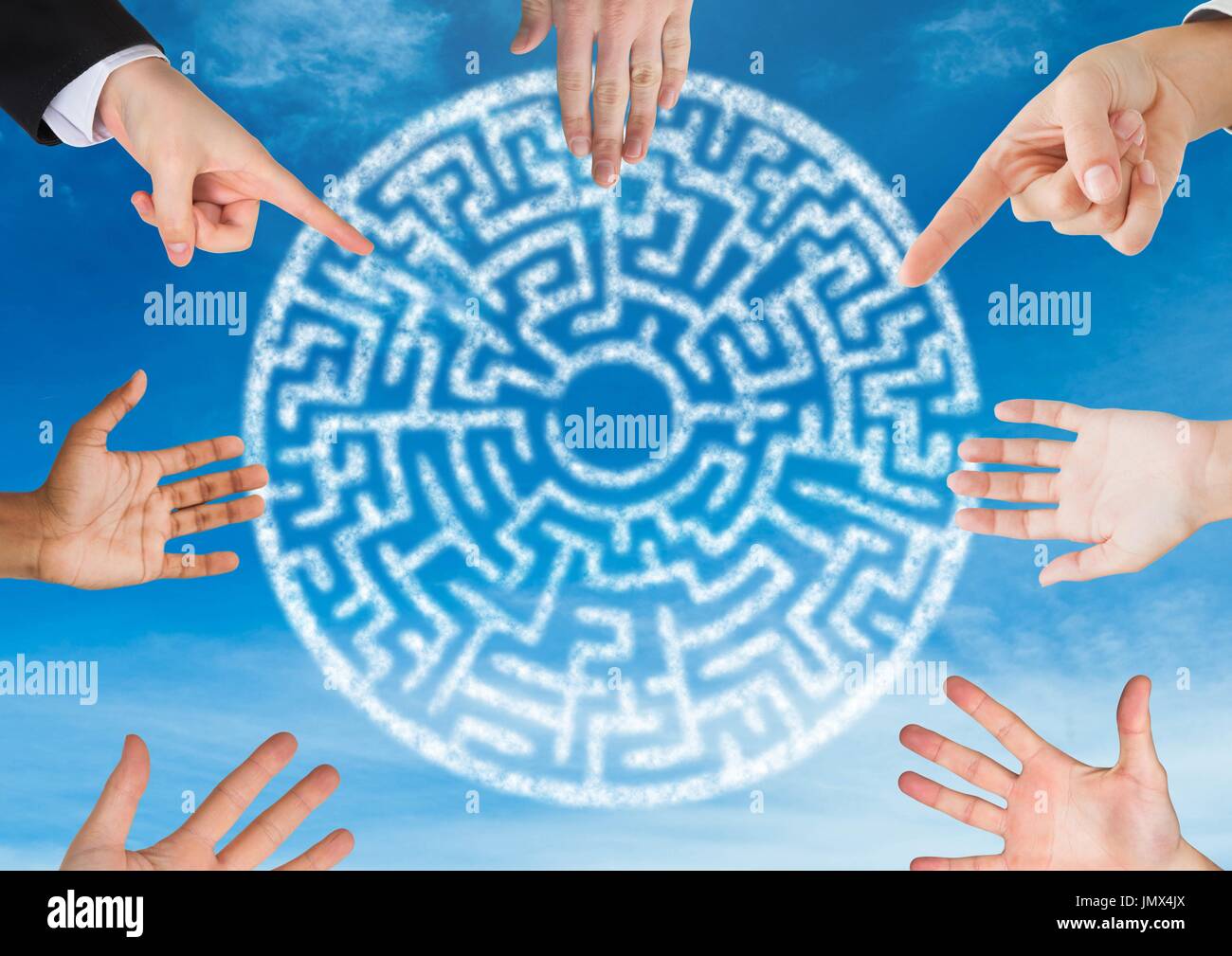 Digital composite of Hands in circle around cryptic maze circle in sky ...