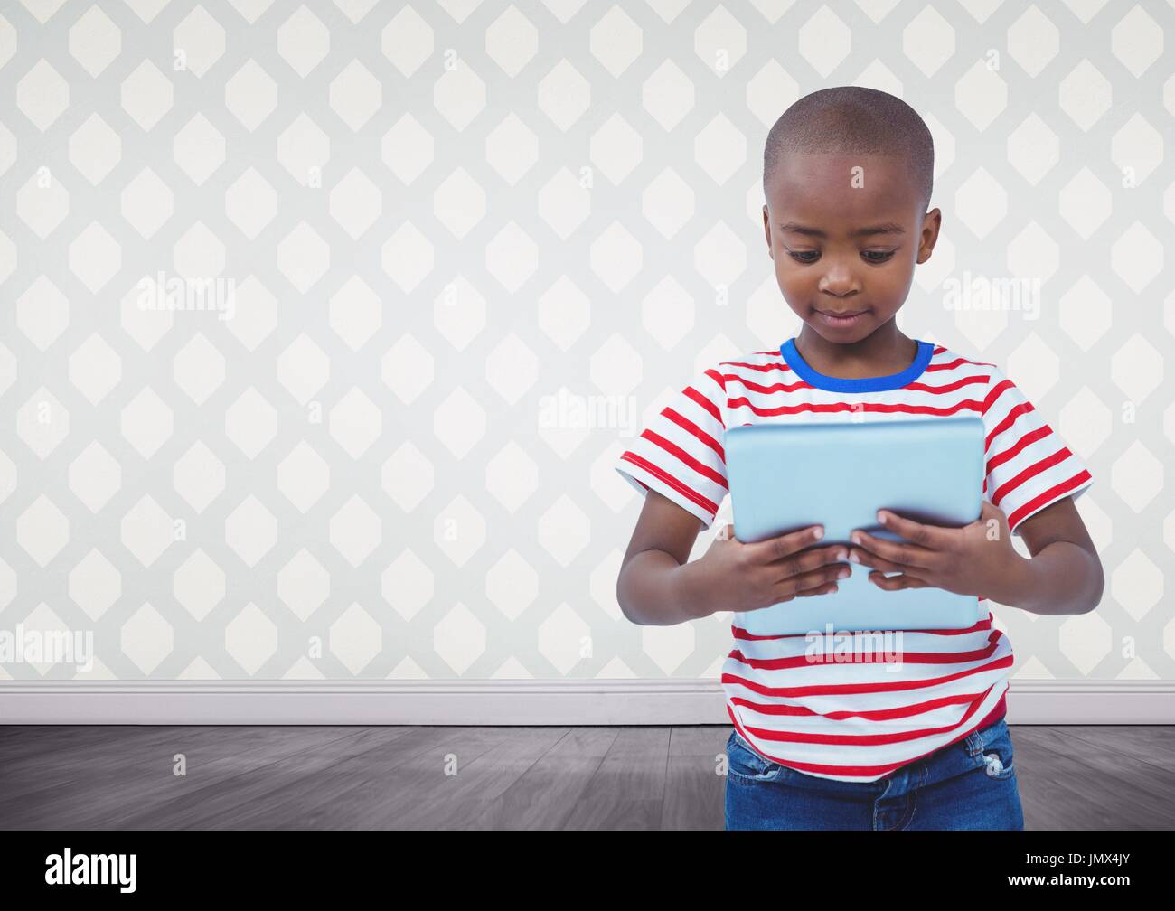 Digital composite of Boy holding tablet in blank room Stock Photo - Alamy