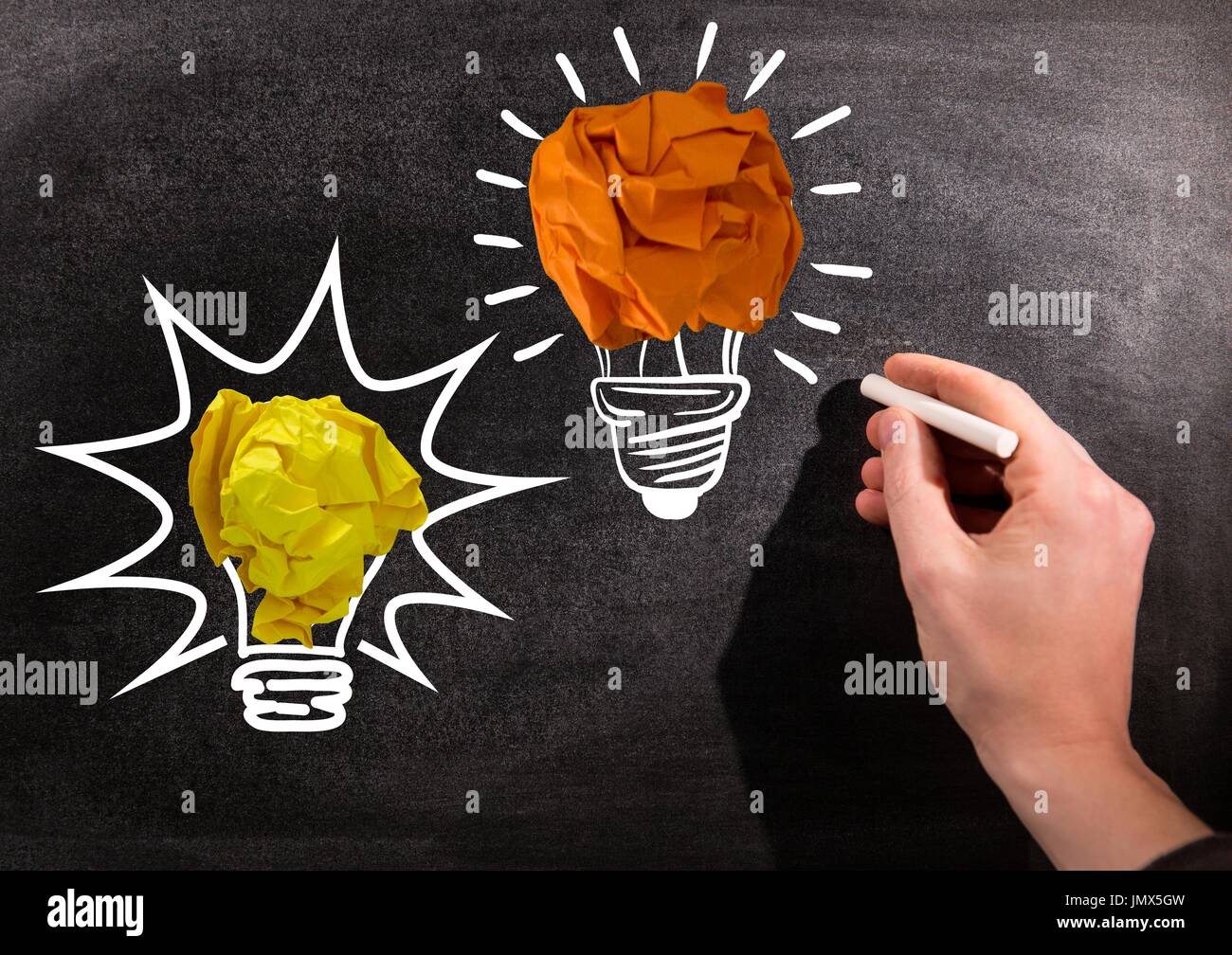 Digital composite of Hand drawing light bulbs on blackboard with chalk ...