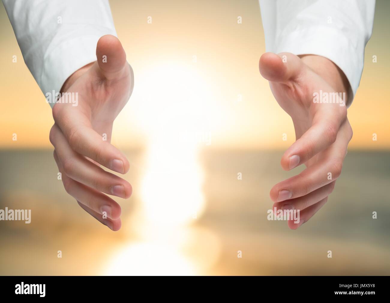 Digital composite of Hands holding invisible energy air with bright ...