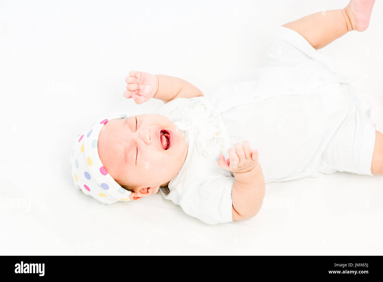 Portrait of a little adorable infant baby girl lying on back on the bed ...