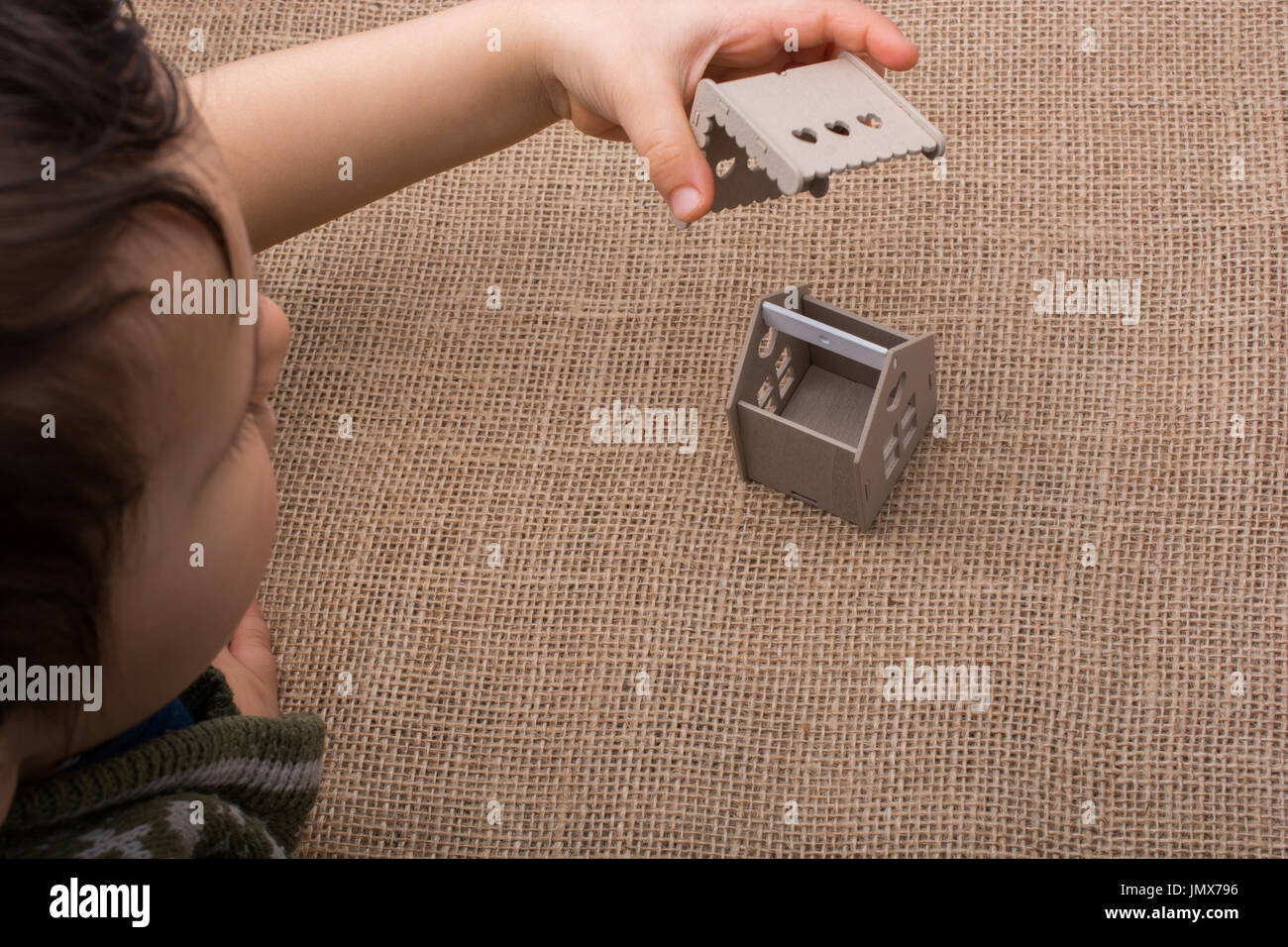 Child holding a model house on a linen canvas Stock Photo - Alamy