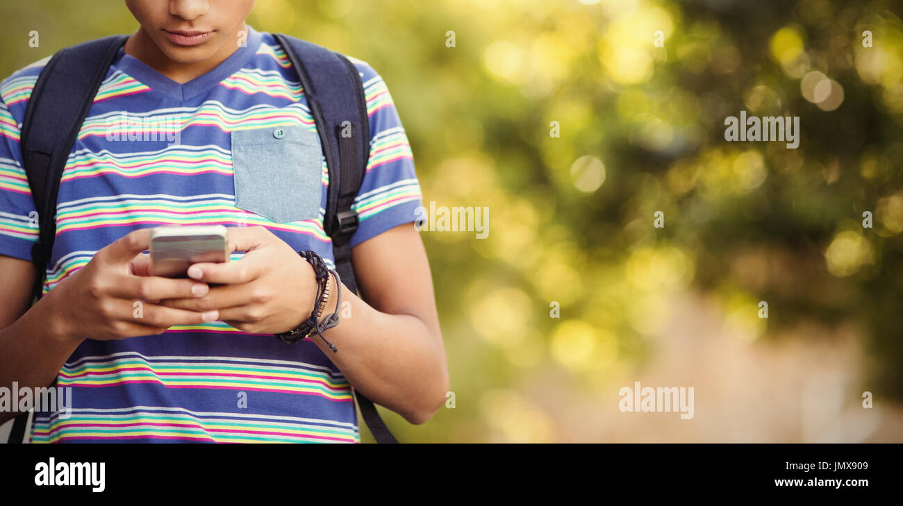 Schoolboy using mobile phone in campus at school Stock Photo - Alamy
