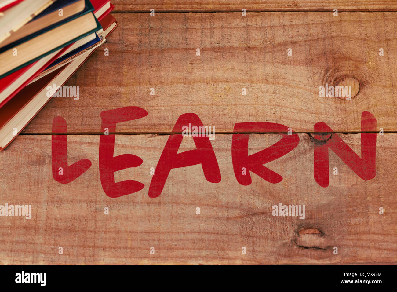 Learn text on white background against stack of books on table Stock ...
