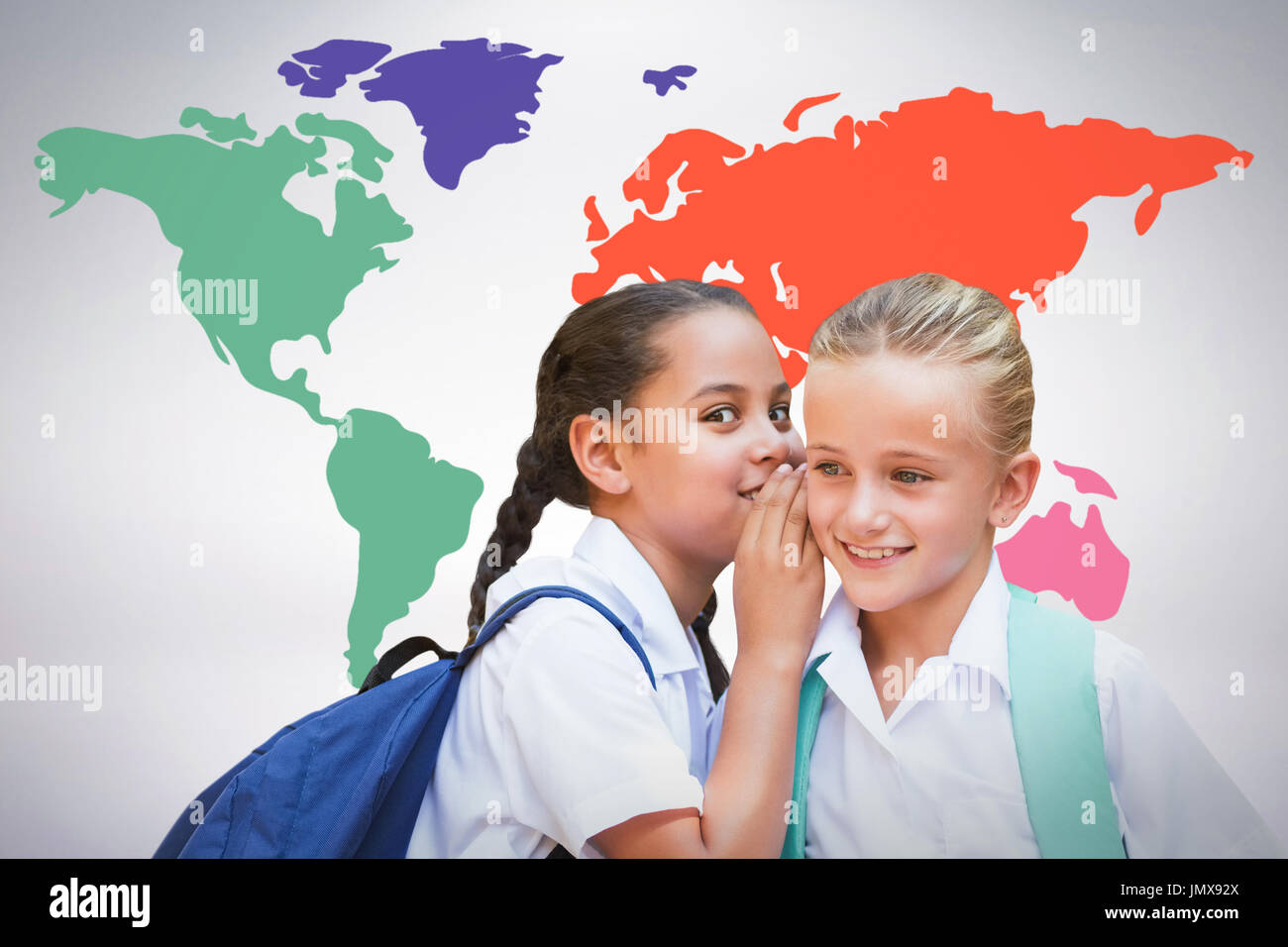 Portrait of girl whispering in friend ear against grey background Stock ...