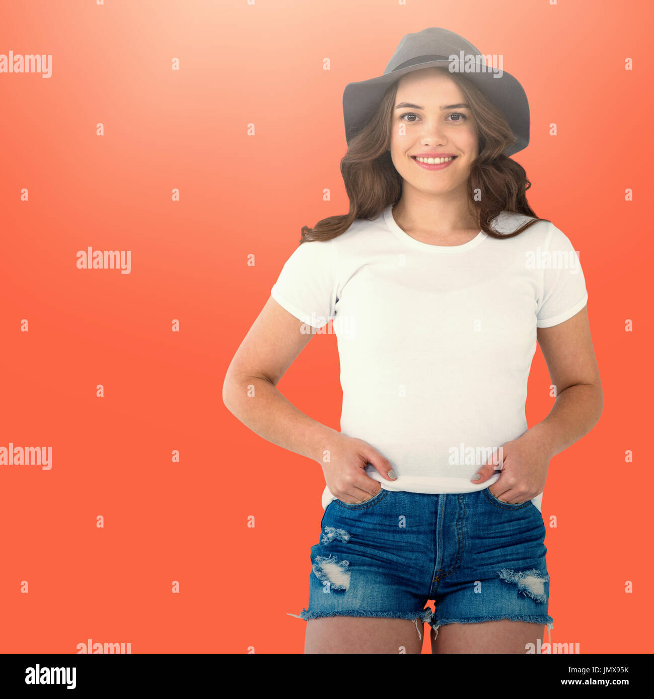 Portrait of beautiful fashion model showing top against red background ...