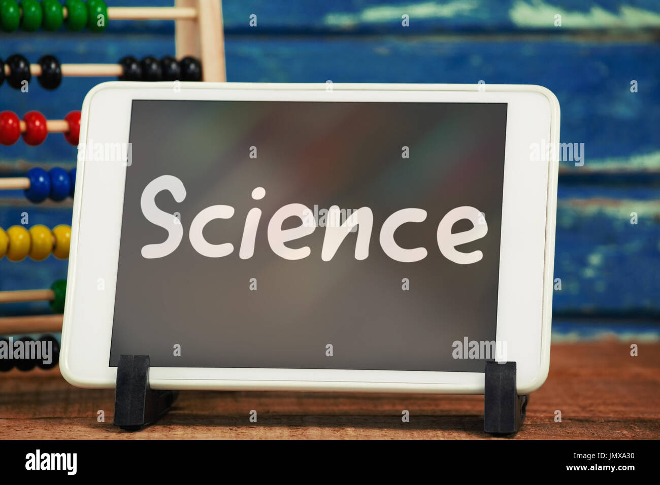 Science text against white background against digital tablet by abacus ...