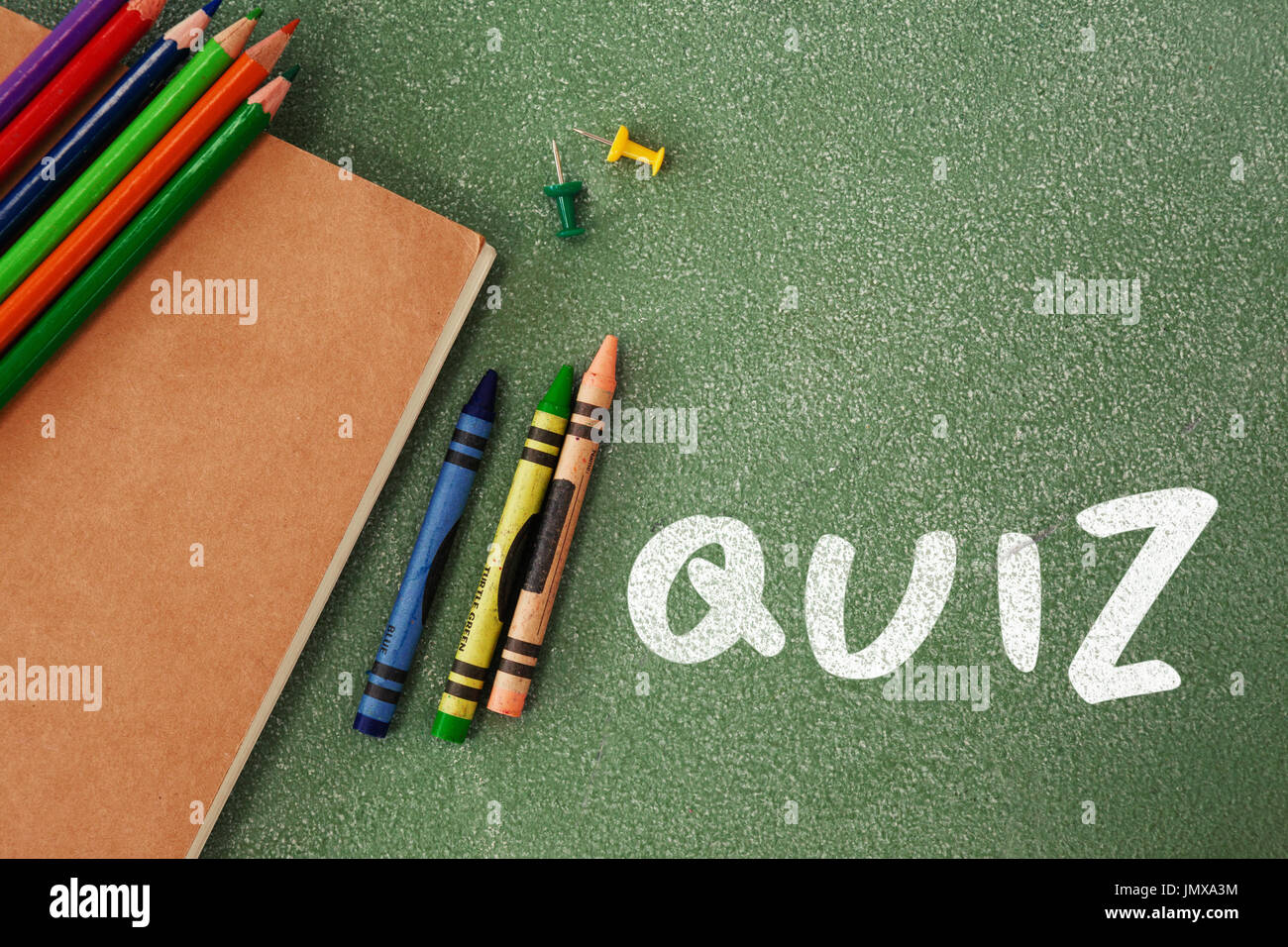Quiz text against white background against high angle view of crayons ...