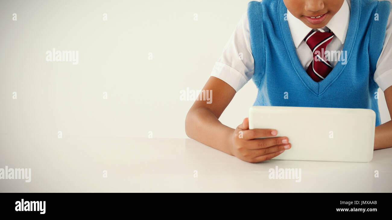 Schoolboy using digital tablet against white background Stock Photo - Alamy