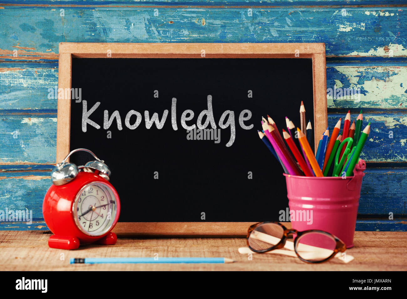 Knowledge text on white background against blackboard with alarm clock ...